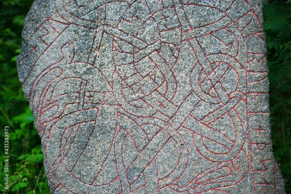 Ancient stone with runes in a green summer park. Enköping, lake Mälaren ...