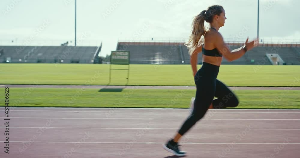 Young athletic woman running at stadium track, working hard and pushing ...