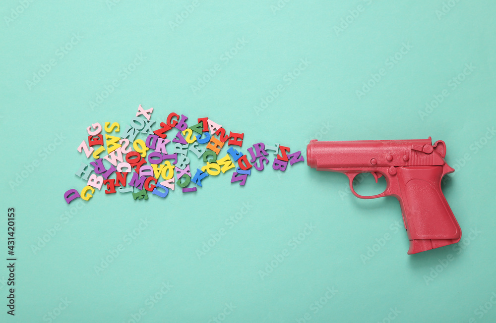 Pink pistol gun shooting colored letters on mint blue background ...