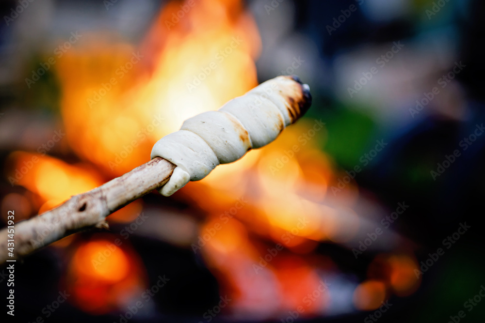 Stick bread twisted on skewer or stick, roasted on flame of fire ...