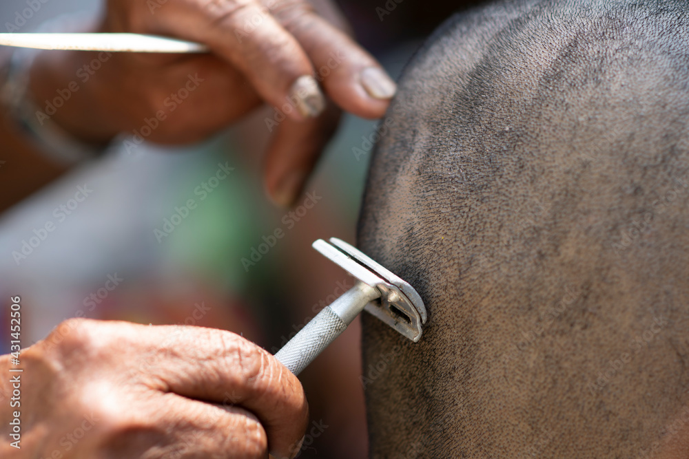 Close-up image of people are using a razor blade to shave their hair ...