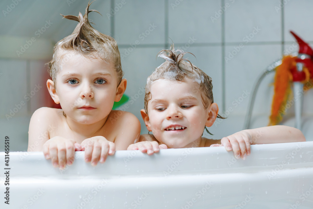 Happy siblings: Two little healthy twins children playing together with ...