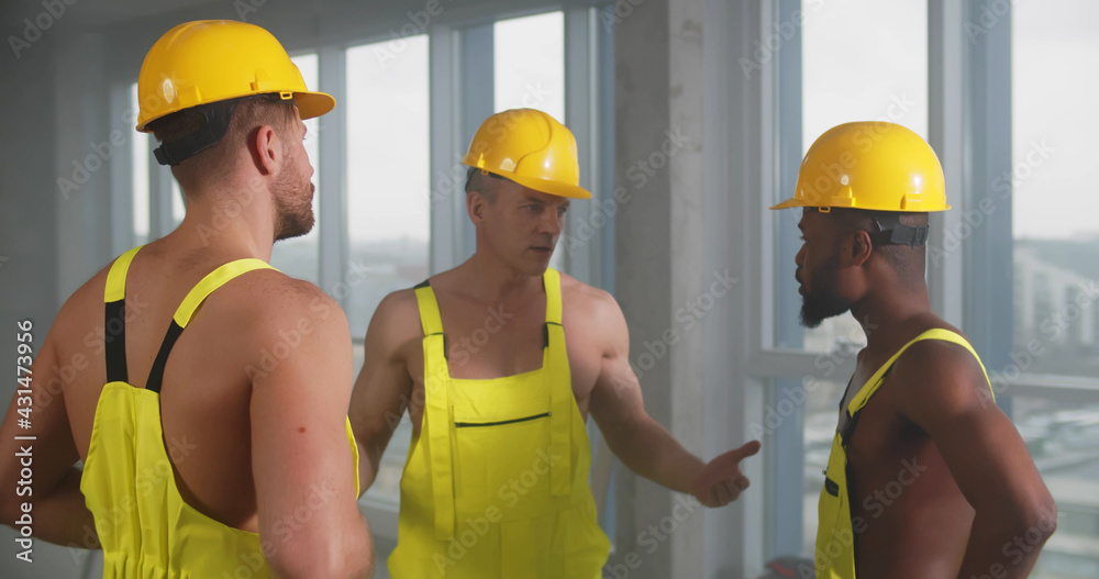 Shirtless diverse builders at construction site talking Stock Photo ...