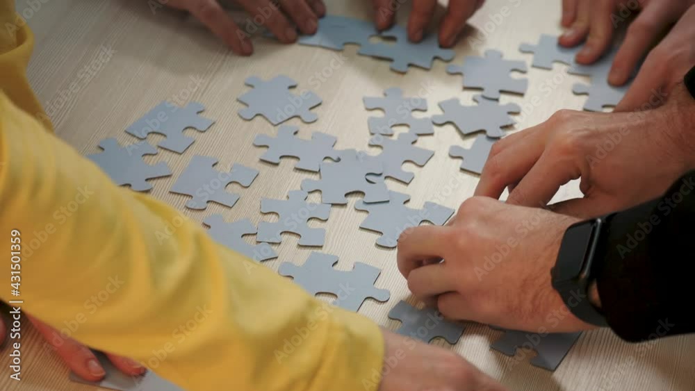 Teamwork. Group of people at table are putting together puzzle. Path to ...