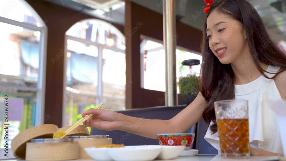 asian woman having a chinese cuisine meal on table at unique cafe ...