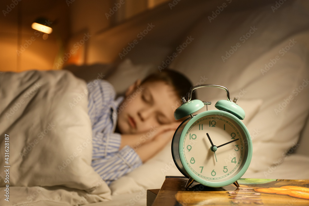 Alarm clock on table of sleeping little boy in bedroom Stock Photo ...