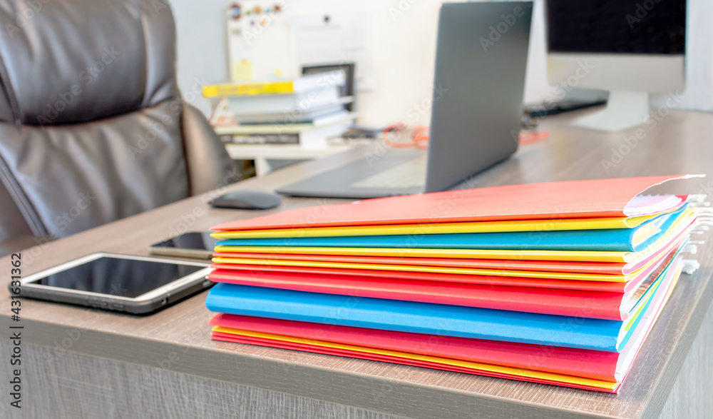 Colorful folders of data report documents stack on manager table with ...