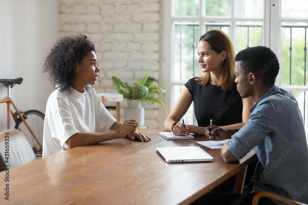 Concentrated young african female job seeker holding interview with two ...