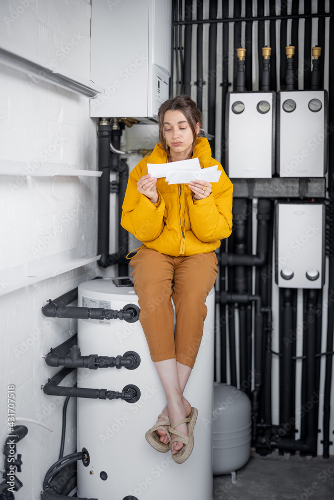 Confused woman looks at electricity bills, comparing data with the ...