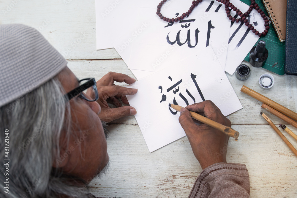 Muslim man writing Khat with bamboo pen on paper, Arabic letters mean ...