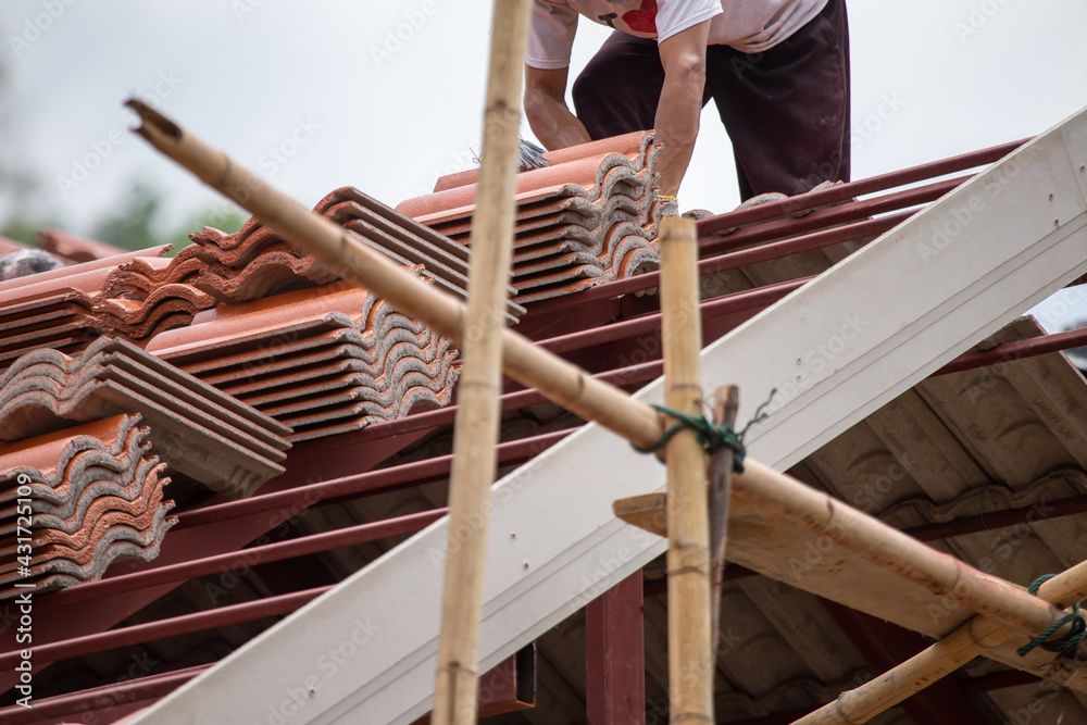 New orange roof tiles, thick plan, are being assembled on the roof by ...