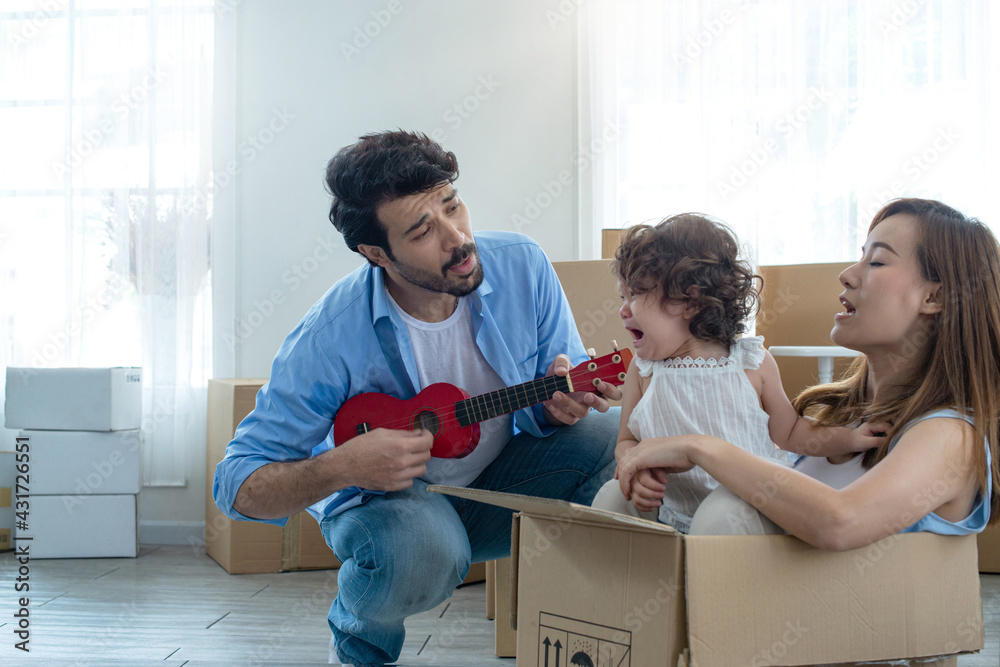 Little girl crying, her father consoled her by playing the ukulele ...
