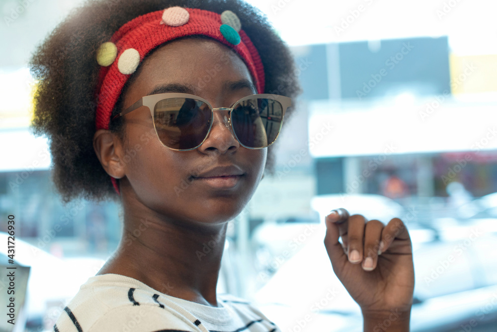 African girl with new glasses in optical shop, young woman is choosing ...