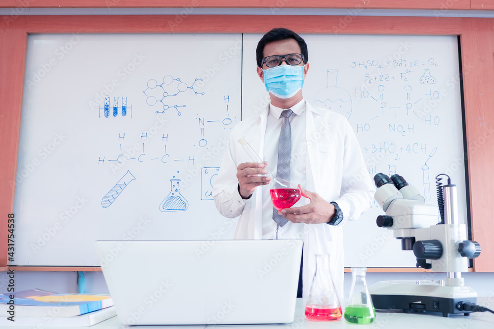 Science teacher wearingmask and teaching with using microscope in the ...