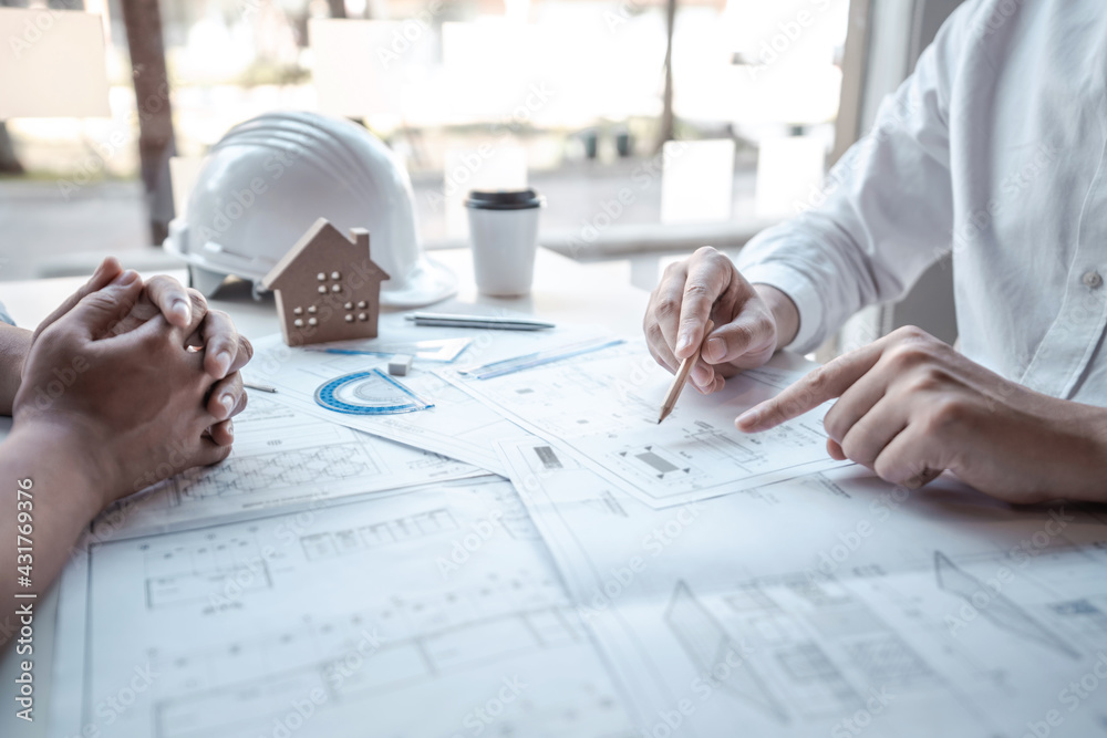 Team of architects or engineering consulting and analyzing working on ...