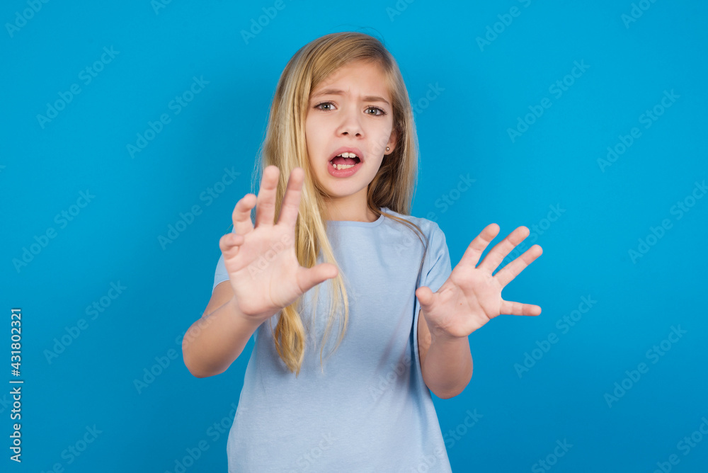 Dissatisfied beautiful Caucasian little girl wearing white T-shirt over ...