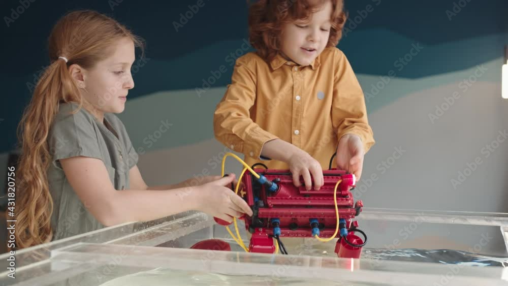 Medium shot of Caucasian teenage boy and girl conducting experiment in laboratory in school. Two ...