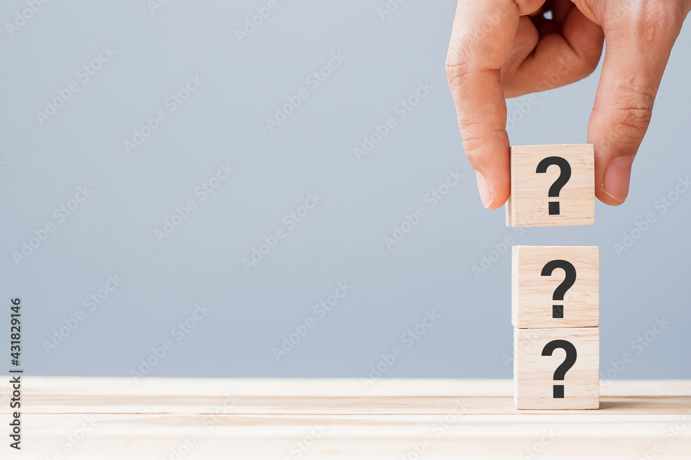 hand holding Questions Mark ( ? ) on wooden cube block on table ...