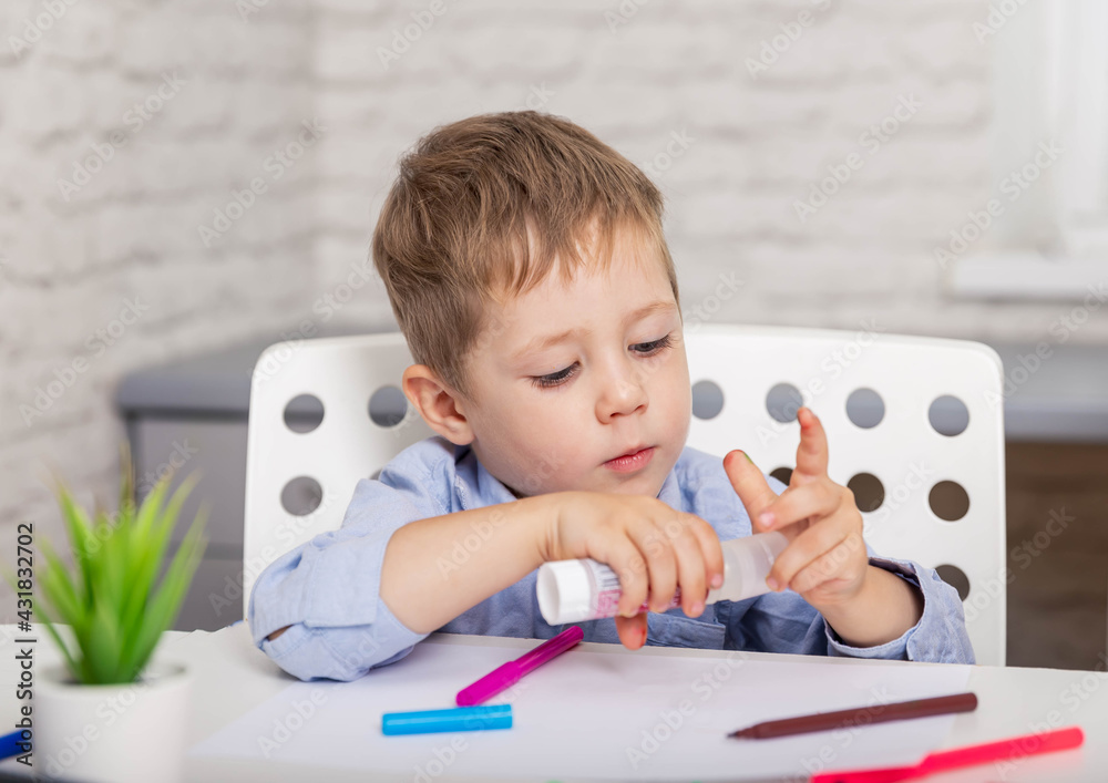 Cute little boy cutting colorful paper at home. Creative kid. Funny ...