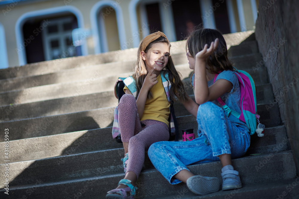 Conversation. Two little girls sitting on stairs and talking. Stock ...