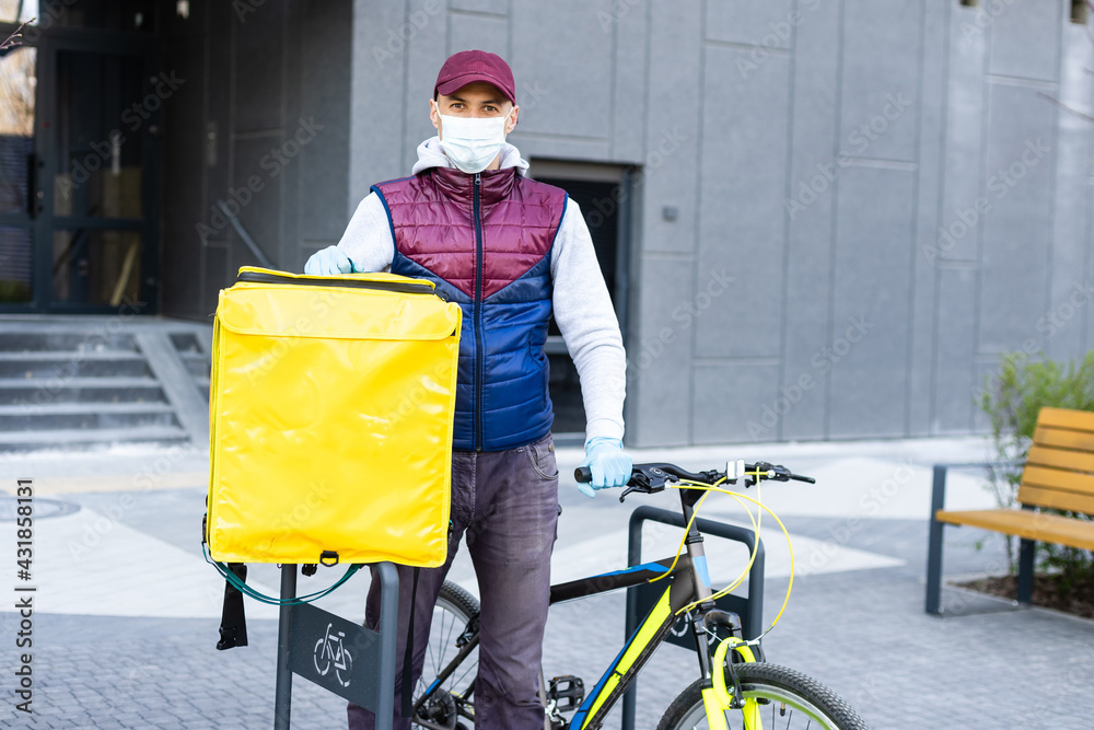 Delivery Man standing with yellow thermo backpack for food delivery ...