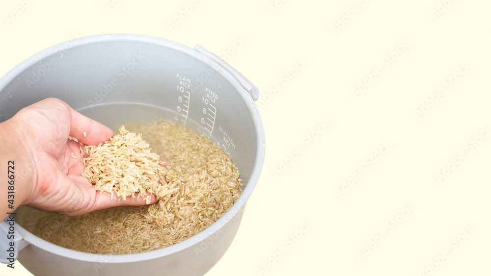 Men hand is washing brown rice or soak for cleaning and preparation ...