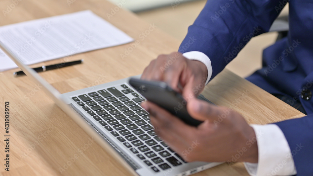 Close up of African Businessman using Smartphone and Laptop Stock Photo ...
