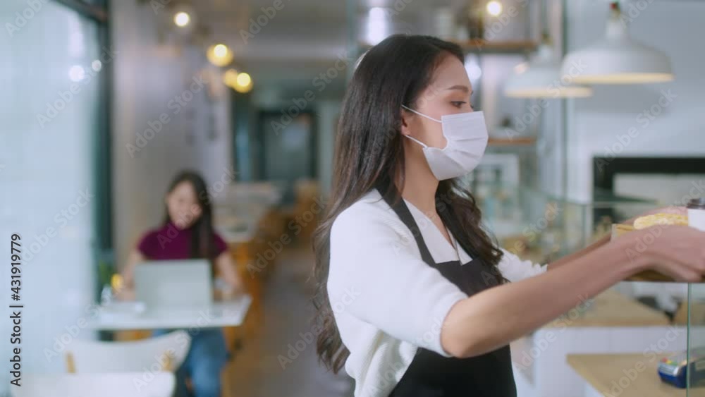 Vidéo Stock Attractive asian female cafe worker wears face mask and ... Vidéo Stock Attractive asian female cafe worker wears face mask and ...