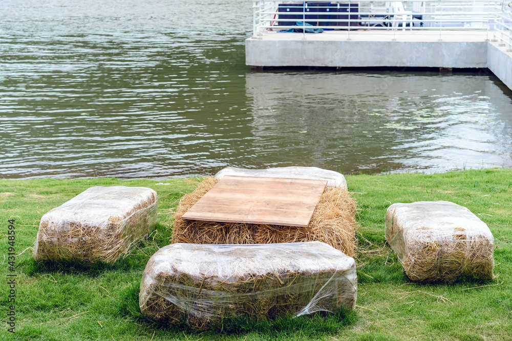 Seats and tables made from straw bales for event and party laid on lawn ...