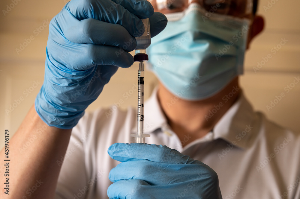 Man drawing liquid for injection into a syringe from a bottle Stock ...