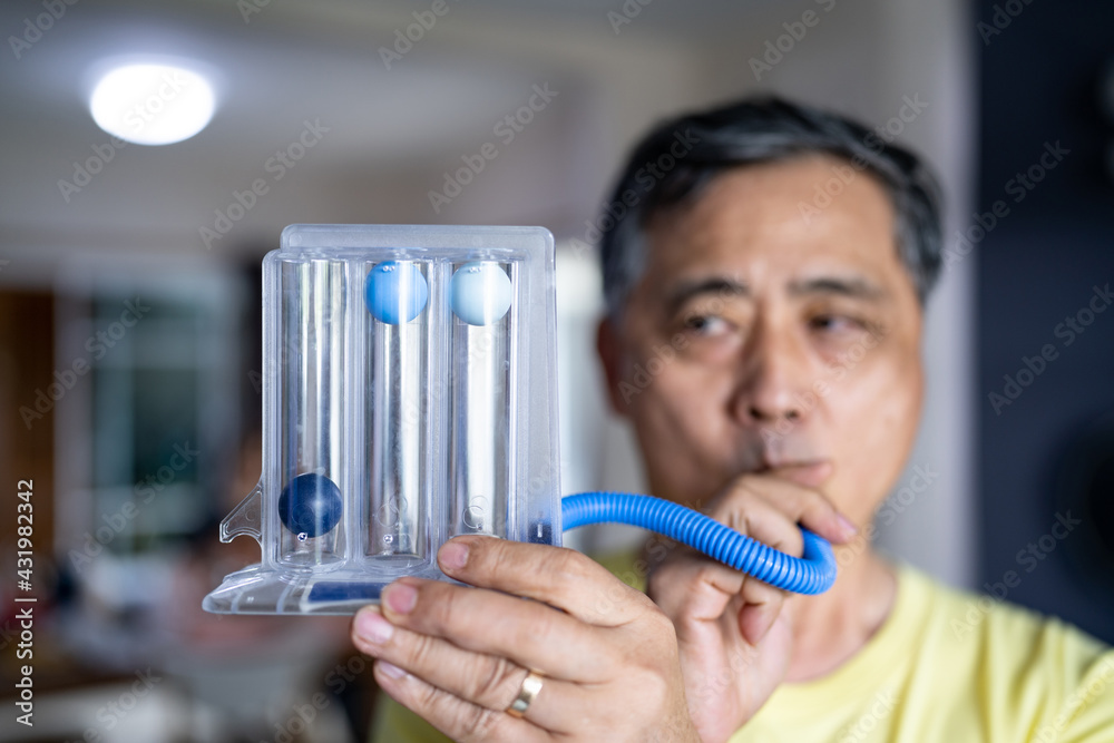 Old man uses a Tri-ball Incentive Spirometer for check his lung ...
