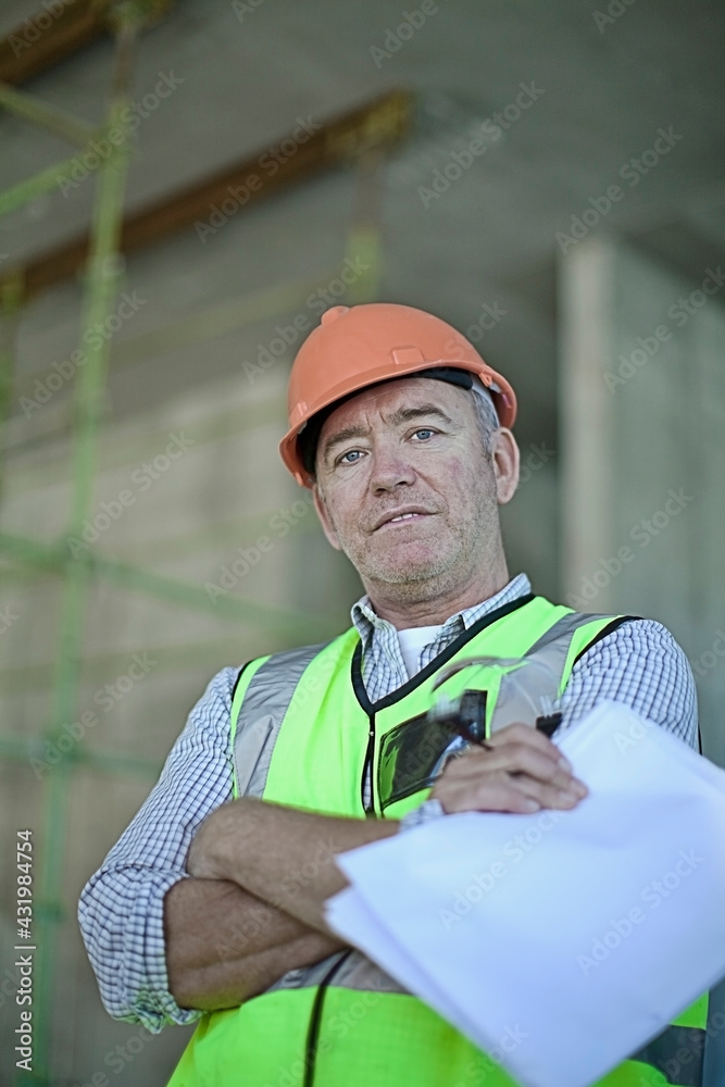 Portrait of male construction worker wearing hardhat standing with ...