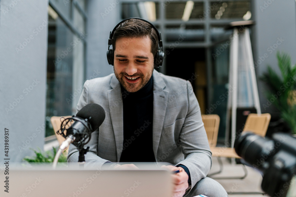 Businessman talking on microphone while sitting at cafe Stock Photo ...