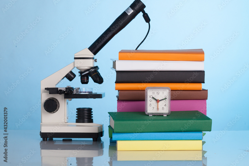 Books and a microscope on the desk of the student Stock Photo | Adobe Stock
