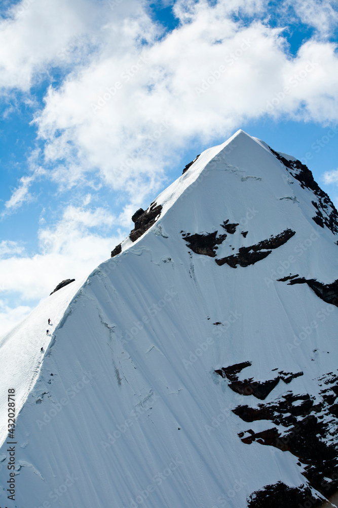 Climbers descend the steep pyramid from the glacier-covered summit of ...