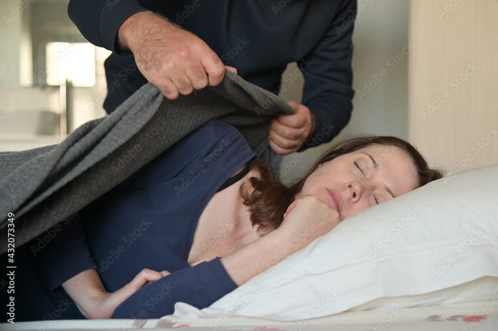 Carrying man covers with a blanket a sleeping woman Stock Photo | Adobe ...