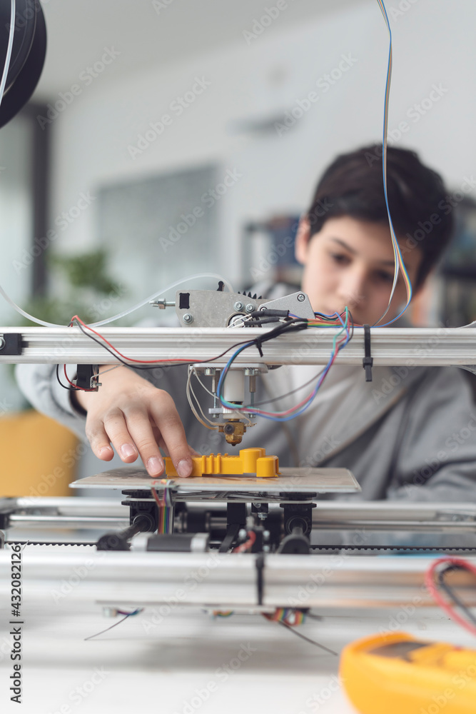 Boy printing a prototype using a 3D printer Stock Photo | Adobe Stock