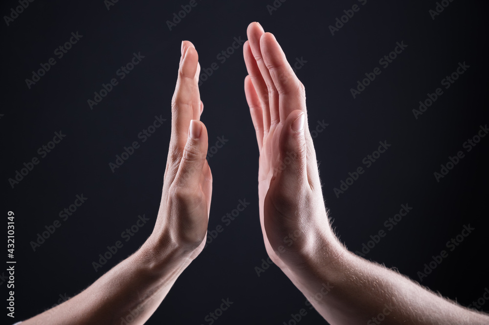 Two Caucasian hands, male and female, on a dark background prepared to ...