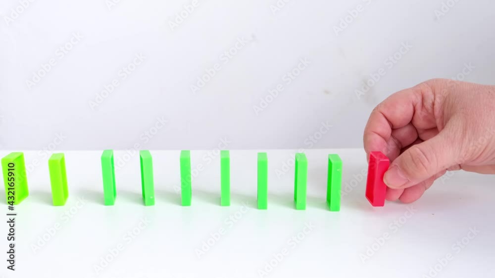 close-up of falling crumbling dominoes. Line of colored domino cubes ...