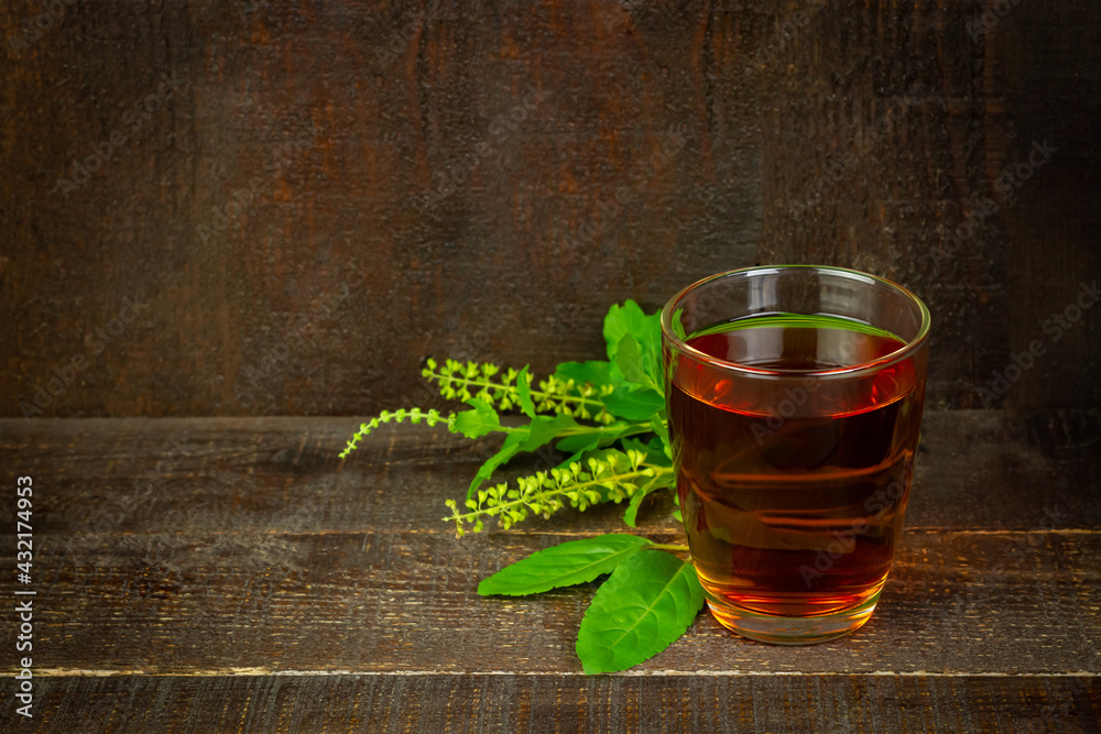 Tulsi or holy basil tea in transparent glass cup with fresh tulsi leaf ...