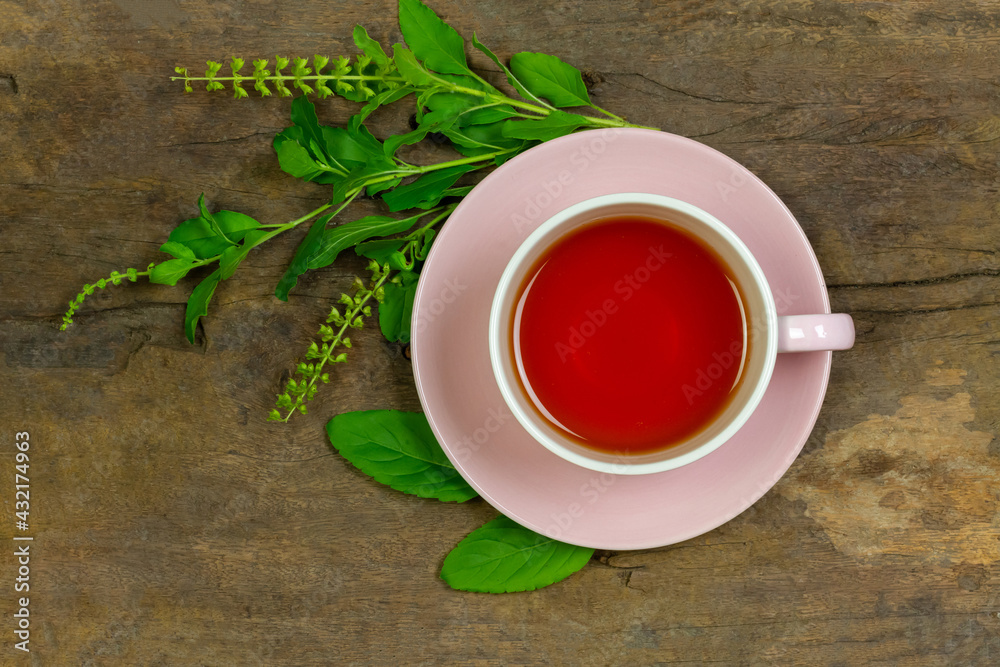Tulsi or holy basil tea in ceramic cup with fresh tulsi branch on ...
