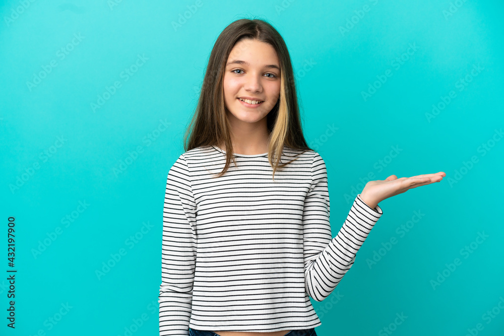 Little girl over isolated blue background holding copyspace imaginary ...