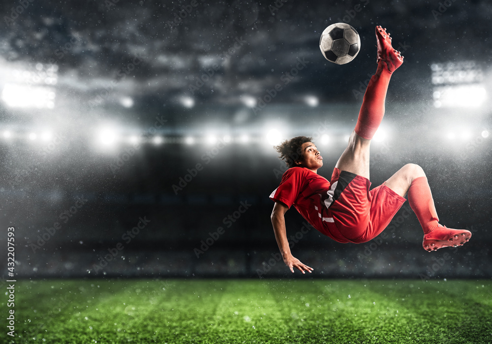Soccer striker in red uniform hits the ball with an acrobatic kick in ...