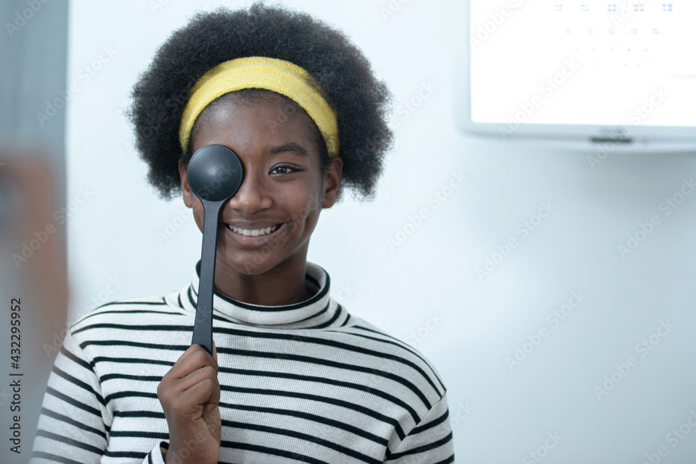Child girl uses occluder to cover one of her eyes for vision test, eyes ...