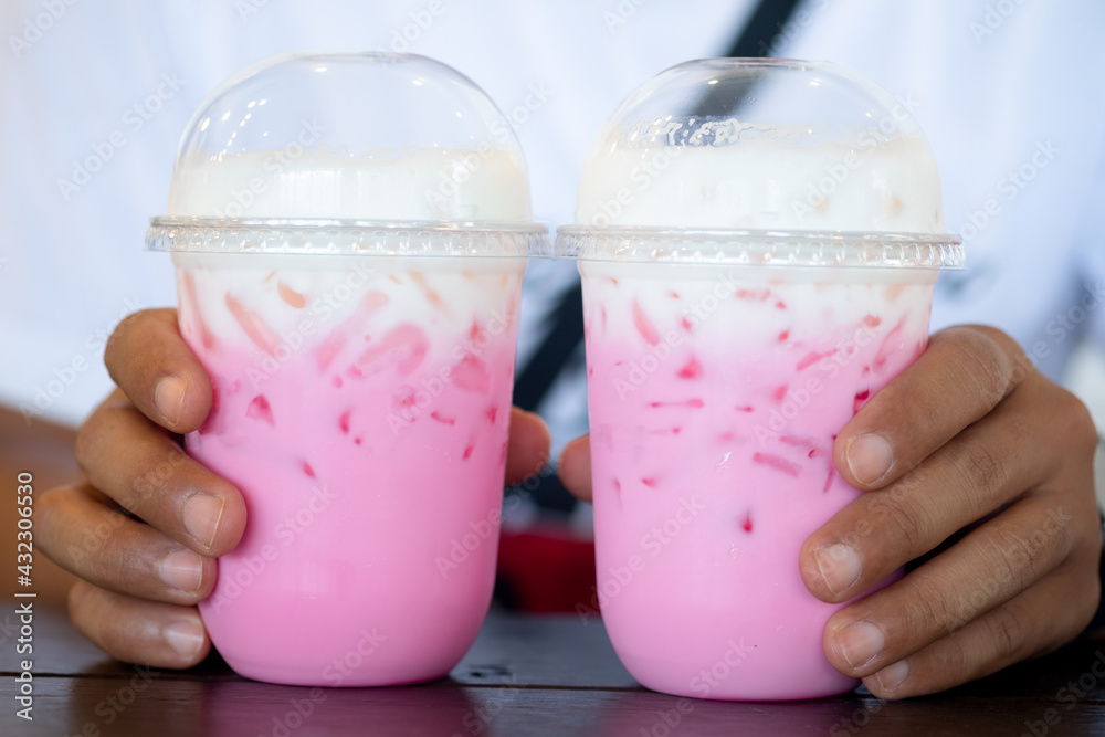 Foto de Hand keep two glass of Thai style iced pink sweet milk is a ...