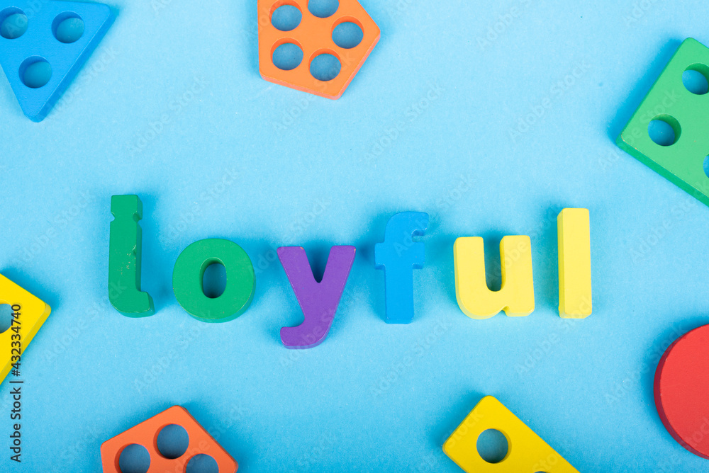 Joyful word written with wooden alphabets blocks on blue chart kids ...