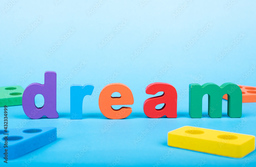 Dream word written with wooden alphabets blocks on blue chart kids ...