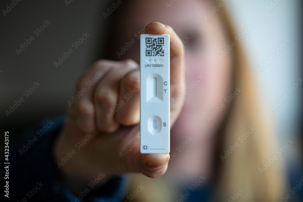 A person holding a covid-19 rapid antigen testing kit at home Stock ...