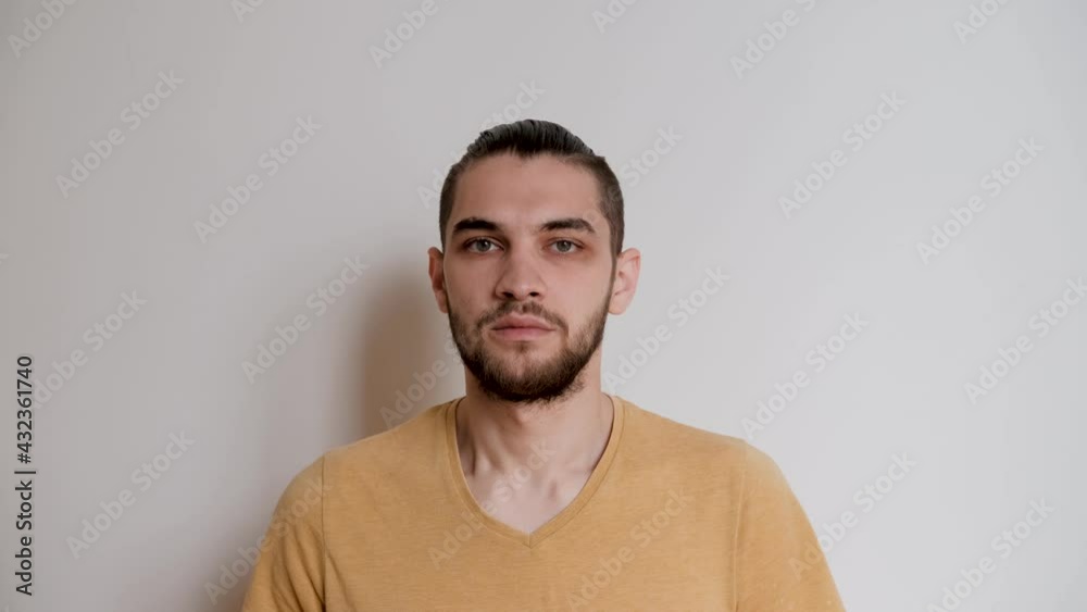 Young handsome Caucasian man with beard and ponytail on his head looks ...