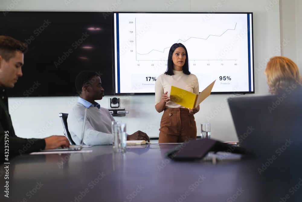 Indian woman giving a presentation to her office colleagues in meeting ...